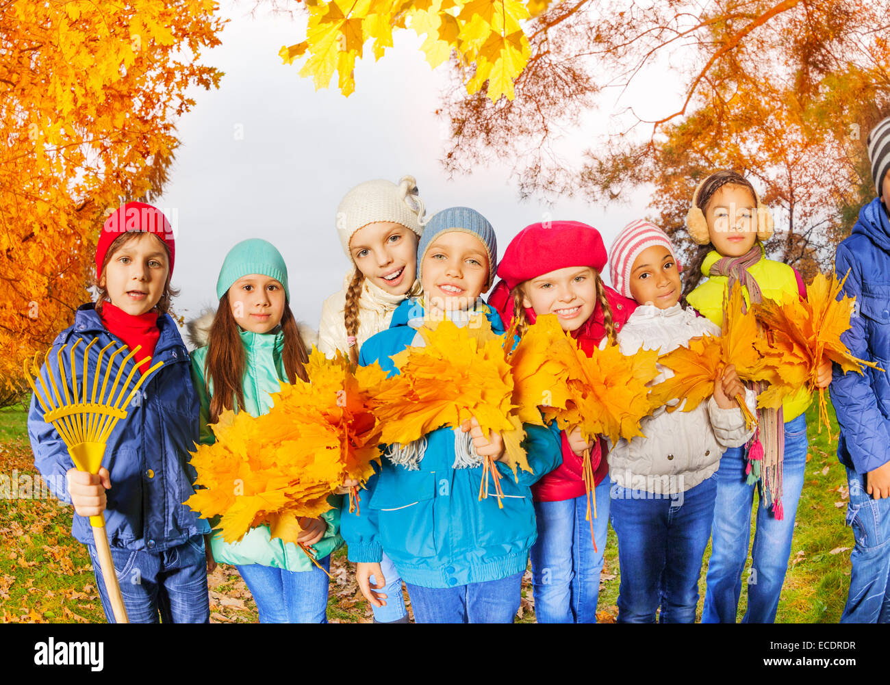 Row of happy kids with rake and leaves bunches Stock Photo - Alamy