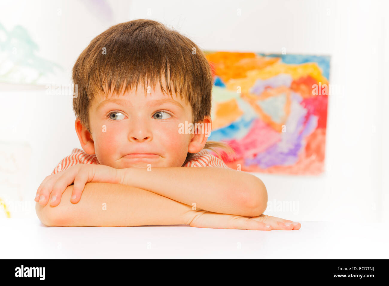Thoughtful portrait of little boy lay on the table Stock Photo - Alamy