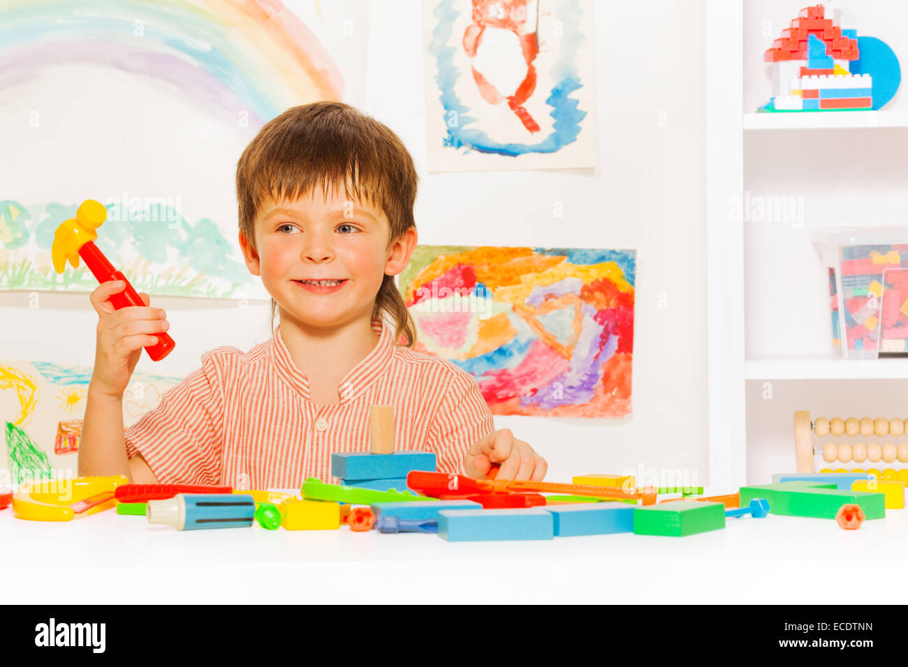Handsome boy with toy hammer in the classroom Stock Photo - Alamy