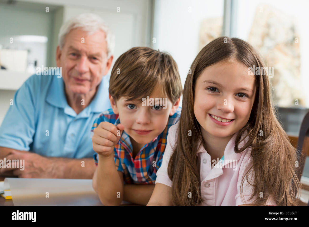 Children doing homework with their grandfather Stock Photo - Alamy