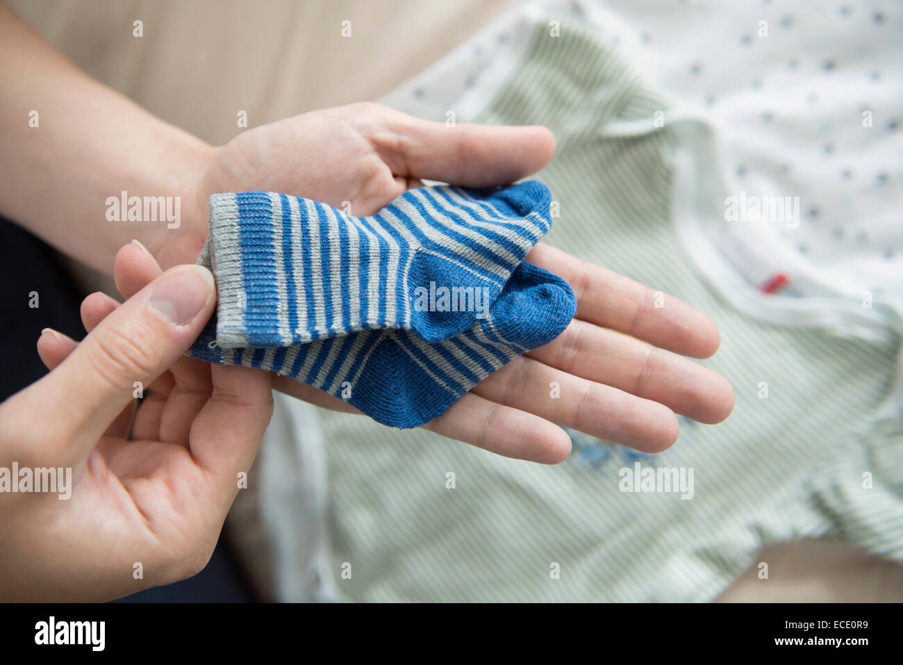 Close-up woman hands holding baby socks Stock Photo - Alamy