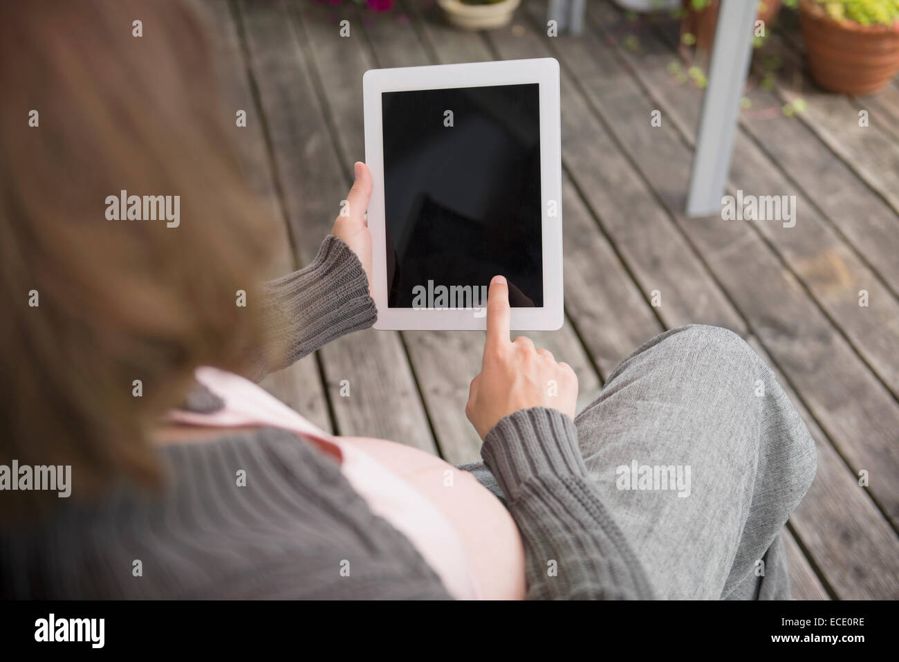 From behind woman holding tablet computer Stock Photo - Alamy