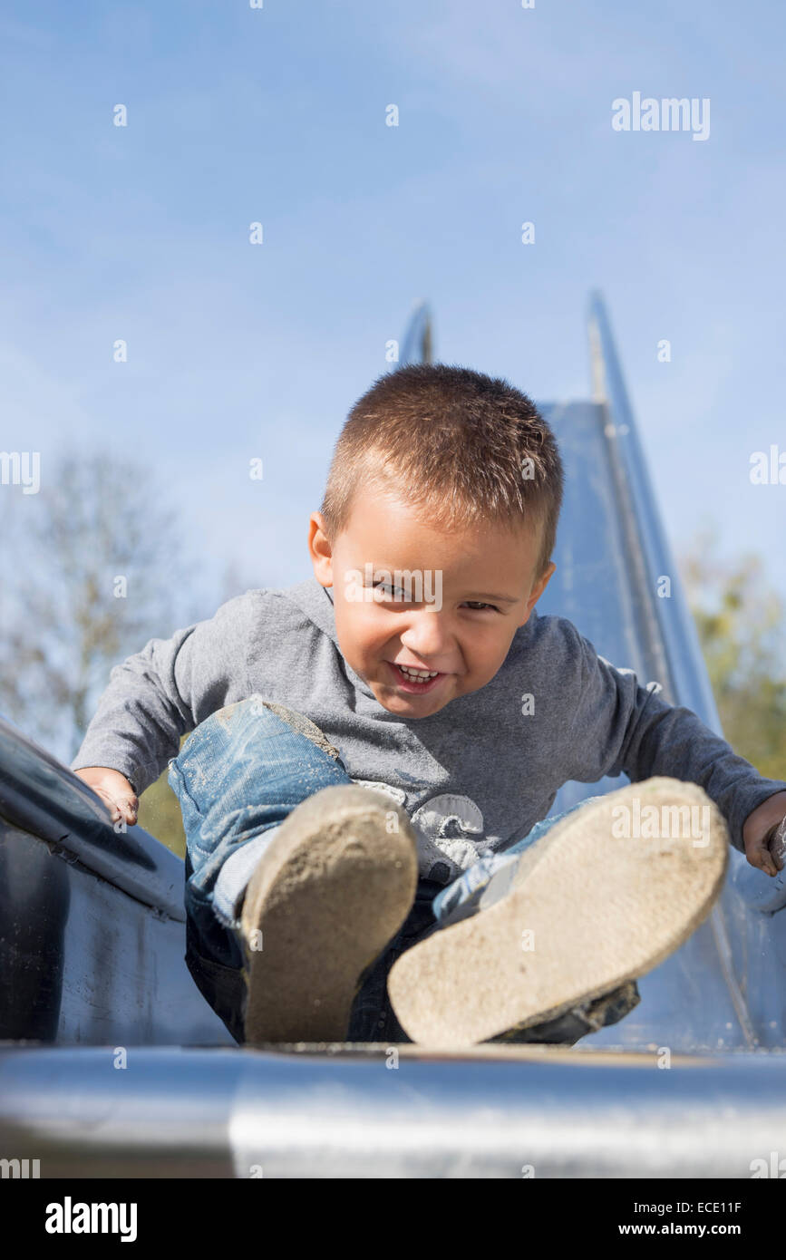 Close up portrait boy sliding playground slide Stock Photo - Alamy