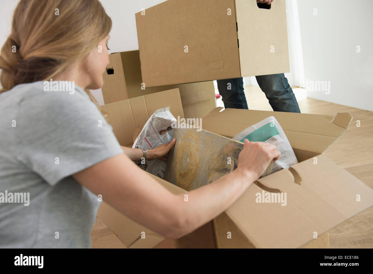 Woman unpacking painting inside carton Stock Photo - Alamy