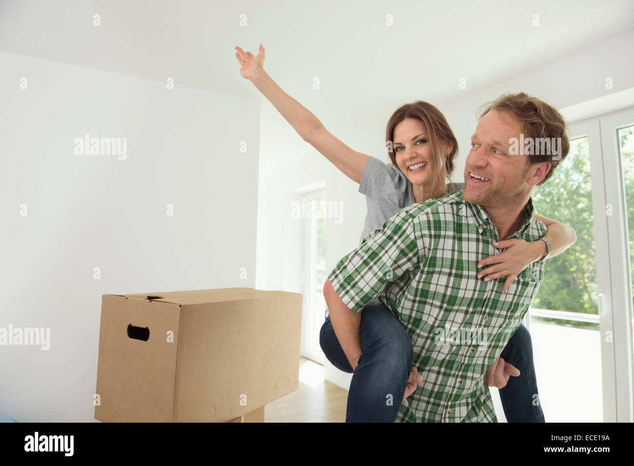 Woman piggyback man new house happy Stock Photo - Alamy