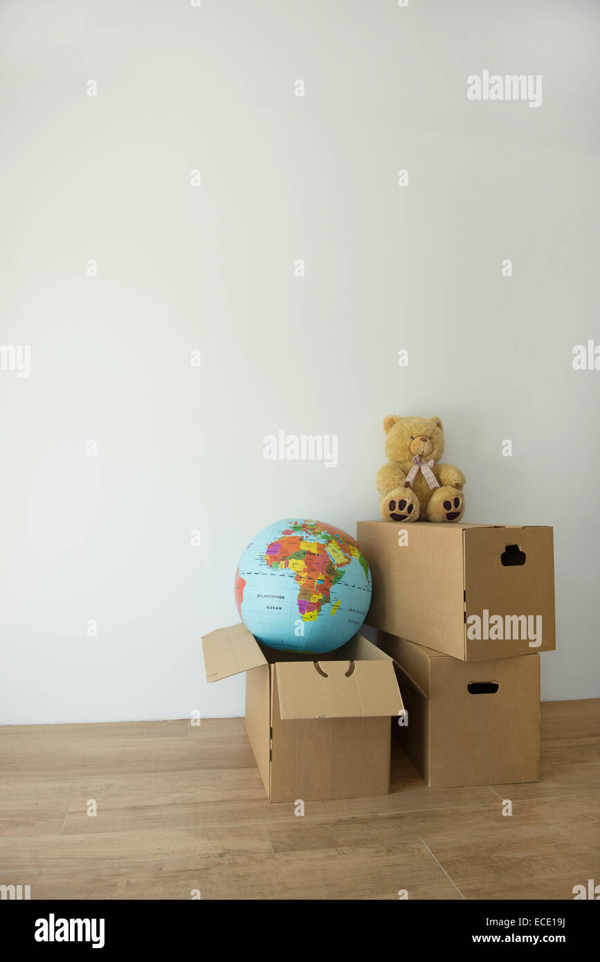 Moving home box globe teddy empty room Stock Photo - Alamy