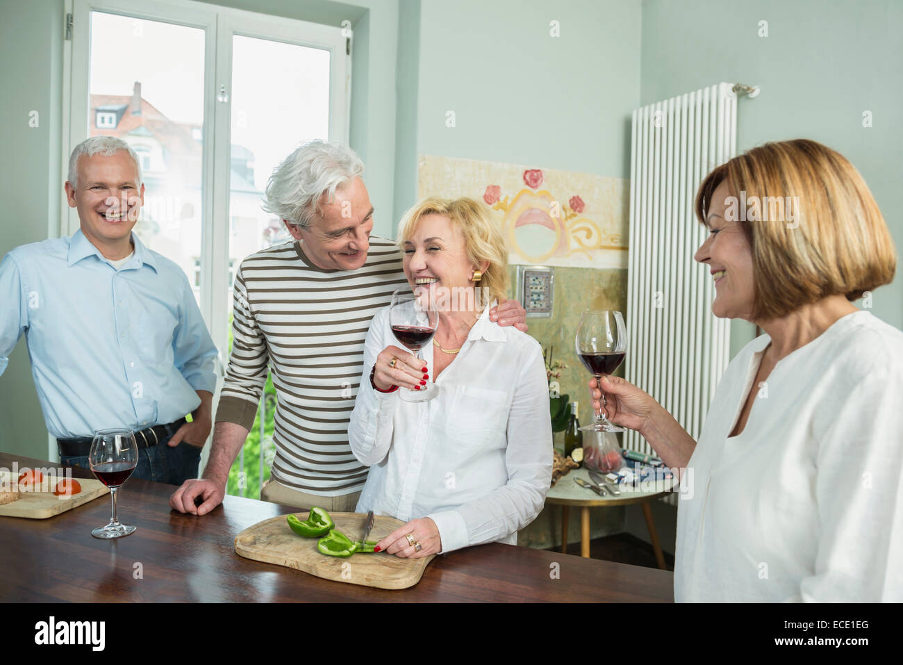 Senior group friends preparing lunch drinking wine Stock Photo - Alamy