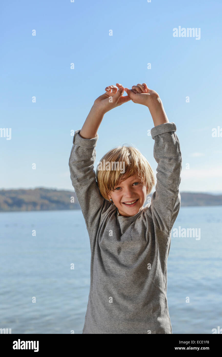 Boy raising arms, smiling, portrait Stock Photo - Alamy