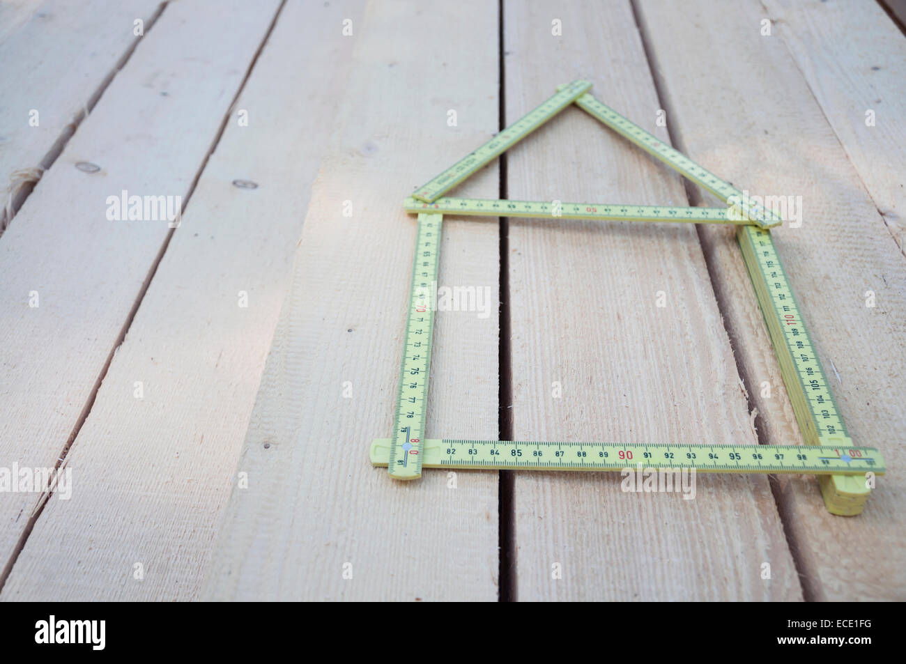 Folding ruler shaped as house on wood Stock Photo - Alamy