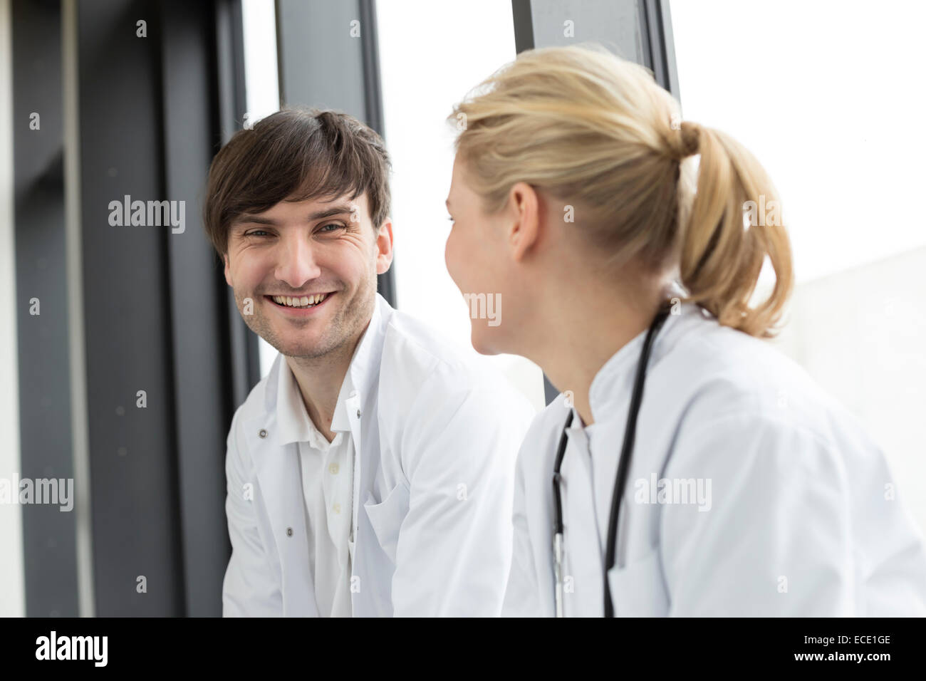 Doctors having conversation, smiling Stock Photo - Alamy
