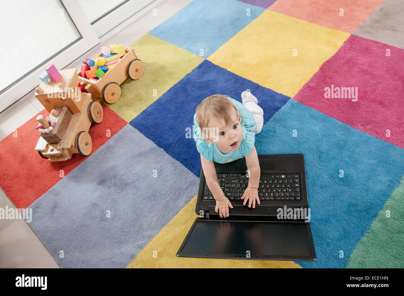 Baby girl typing laptop computer from above Stock Photo - Alamy