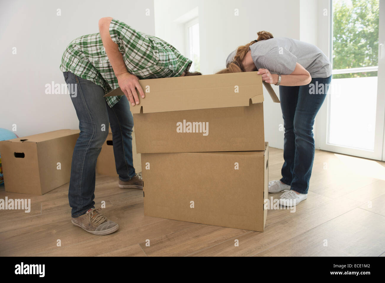 Man woman looking searching inside box Stock Photo - Alamy