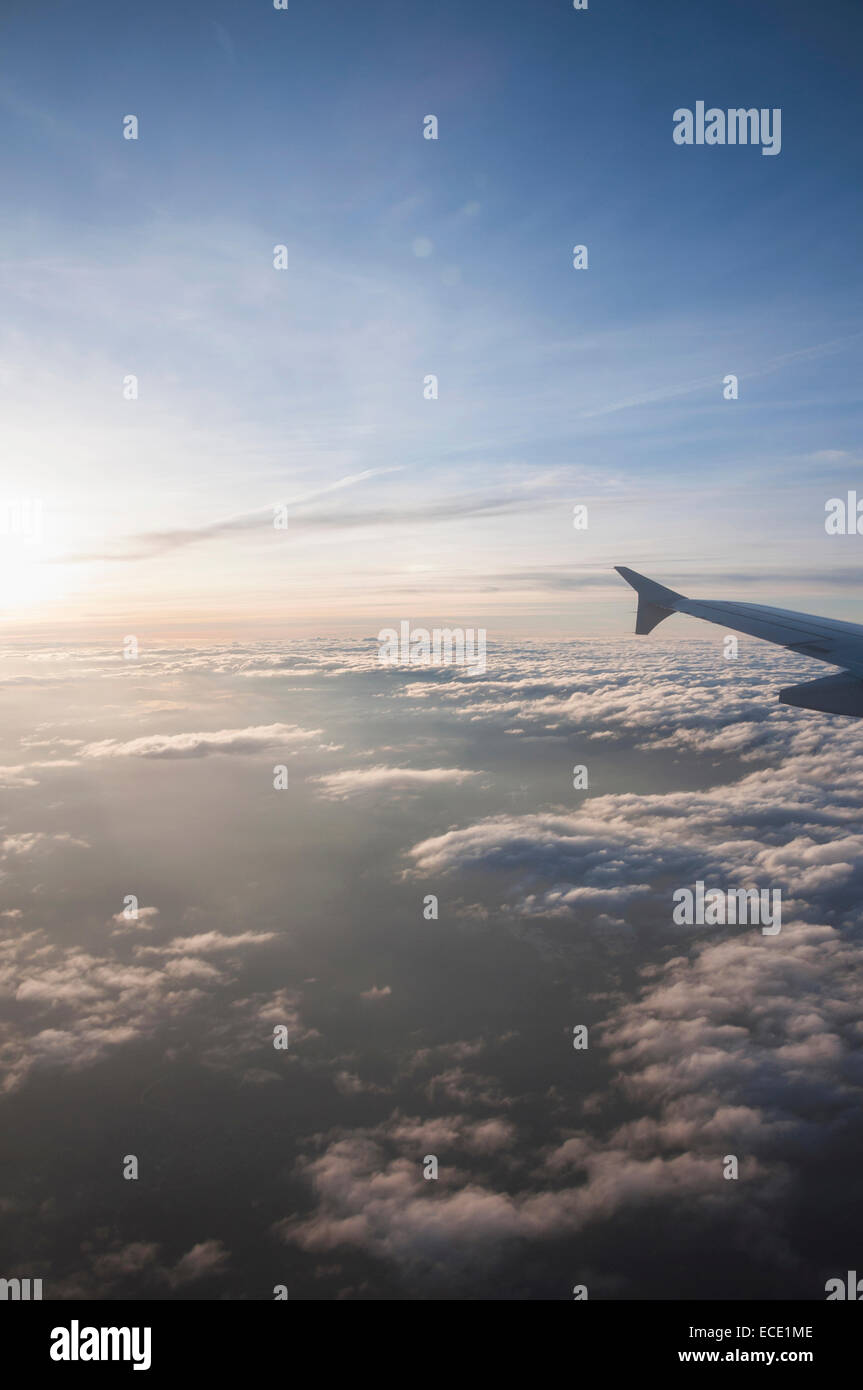 Aerial view of airplane flying over clouds at sunset Stock Photo - Alamy