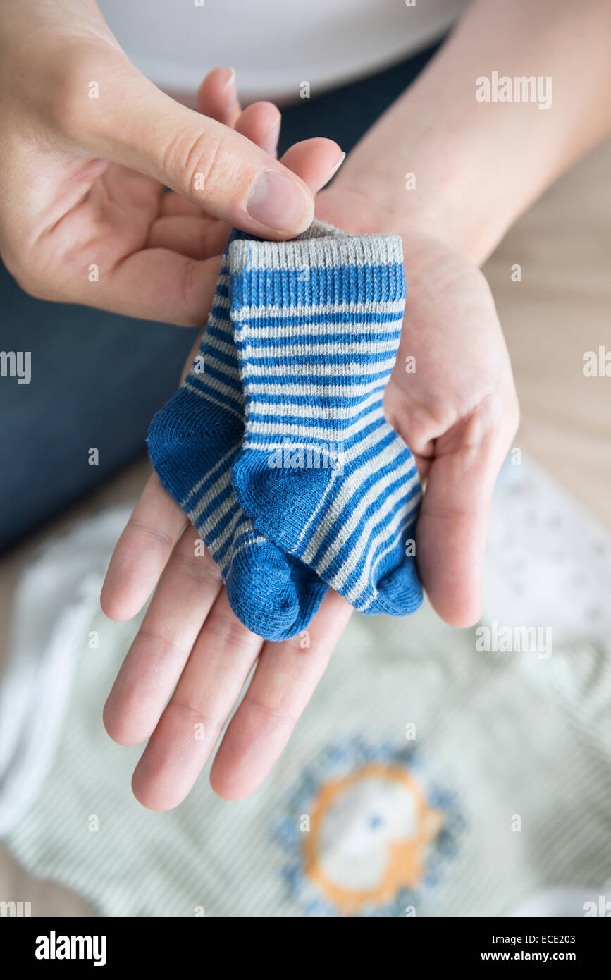 Close-up woman hands holding baby socks Stock Photo - Alamy