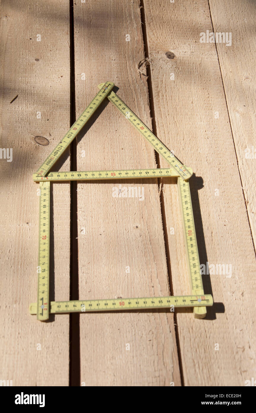 Folding ruler shaped as house on wood Stock Photo - Alamy