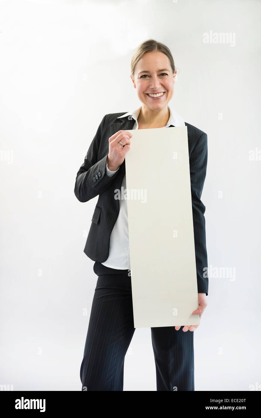 Portrait of businesswoman in black suit holding blank placard, smiling ...
