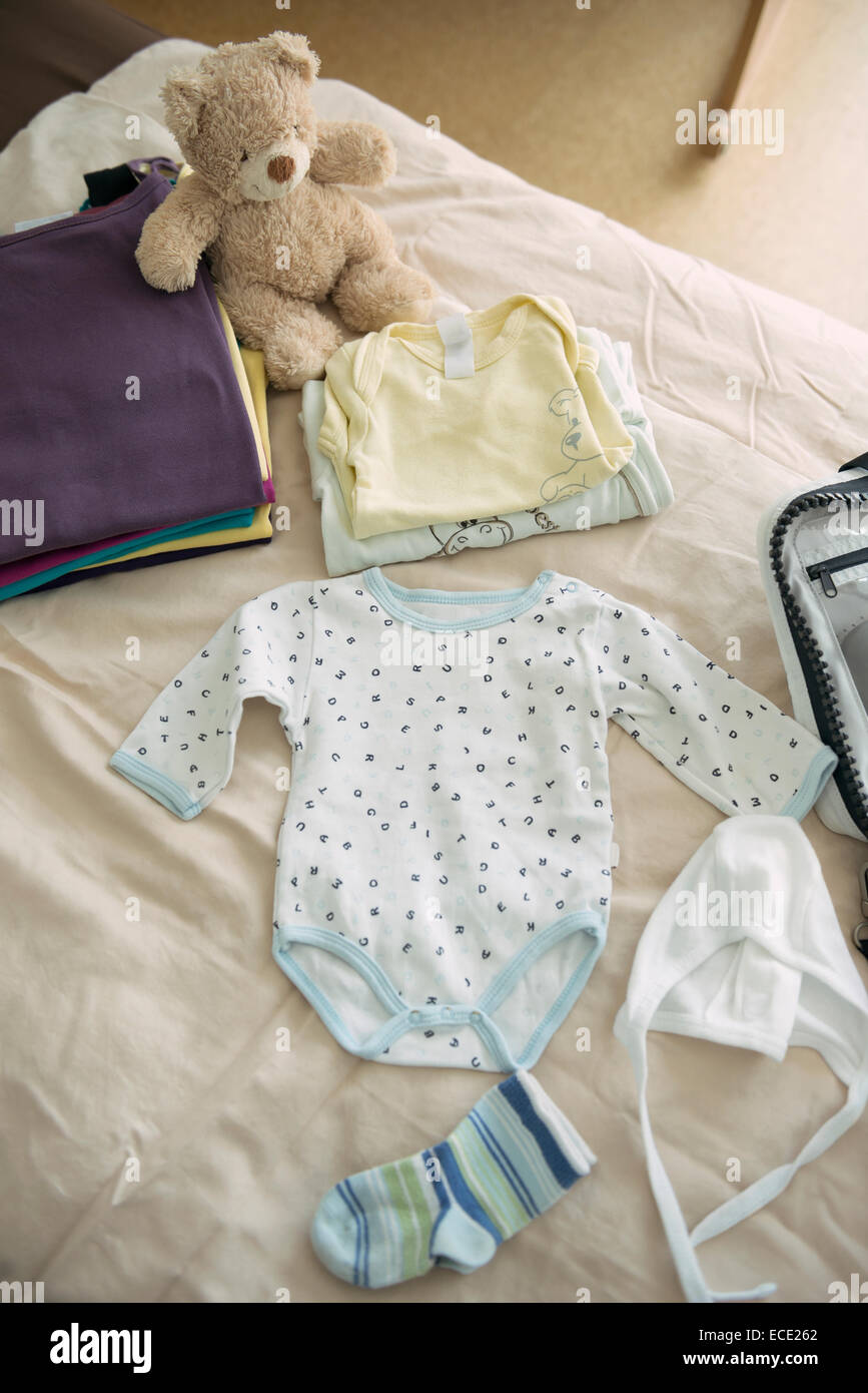 Still life baby clothes bed teddy bear packing Stock Photo - Alamy