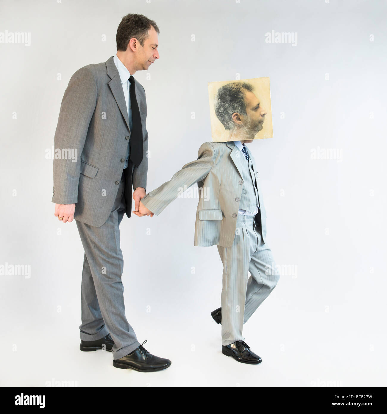 Boy wearing mask pulling businessman towards himself Stock Photo - Alamy