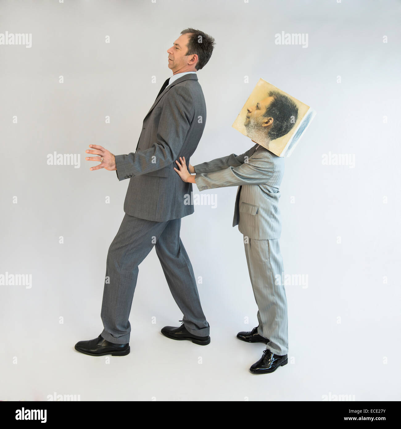 Boy wearing mask pushing businessman Stock Photo - Alamy