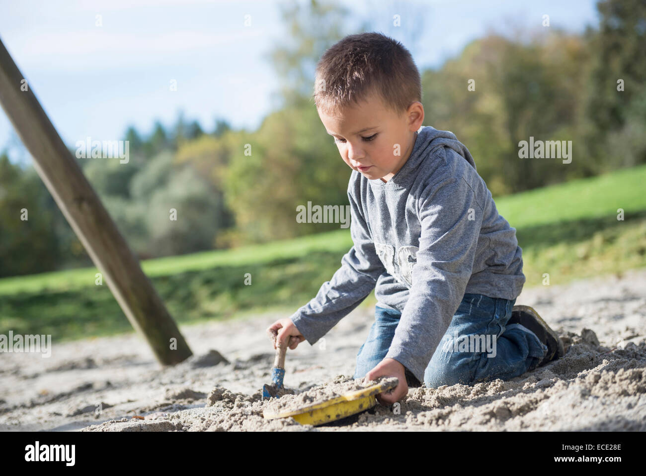 Portrait boy playing shovel sieve sand playground Stock Photo - Alamy