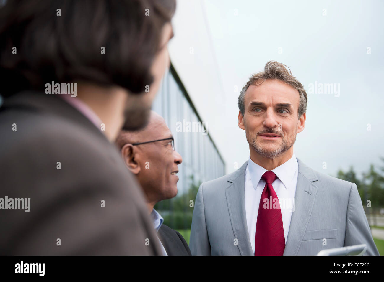 Three men outdoors Partnership conversation Stock Photo - Alamy