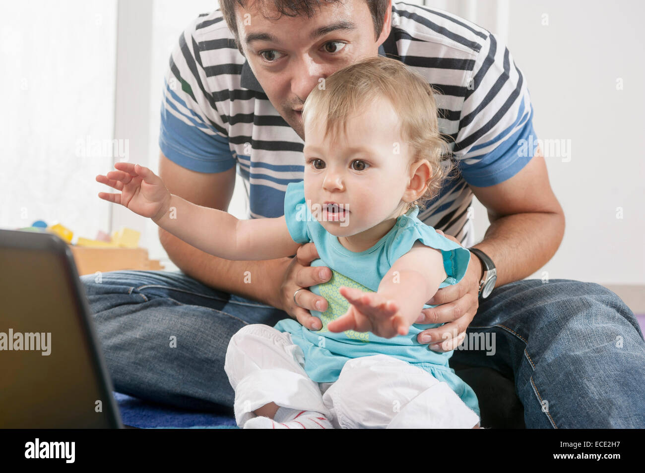 Baby computer laptop father sitting carpet Stock Photo - Alamy