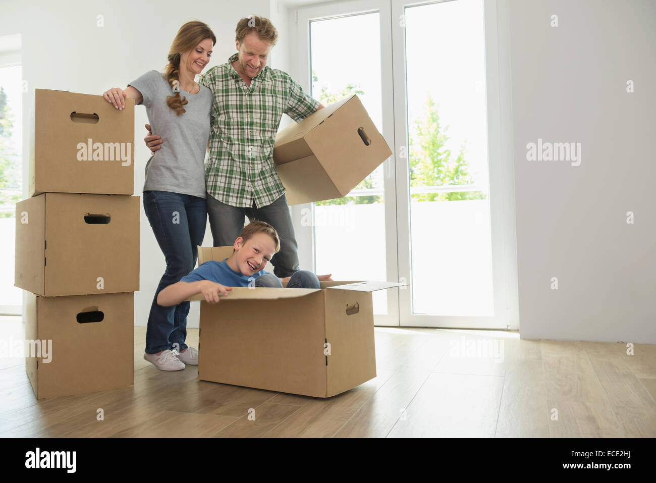 Boxes room young family fun together Stock Photo - Alamy
