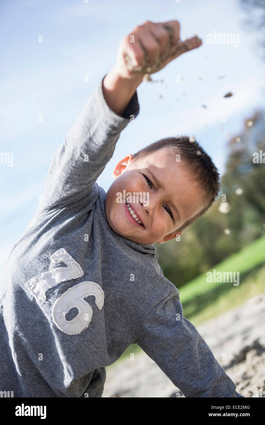 Portrait small boy throwing sand playground Stock Photo - Alamy