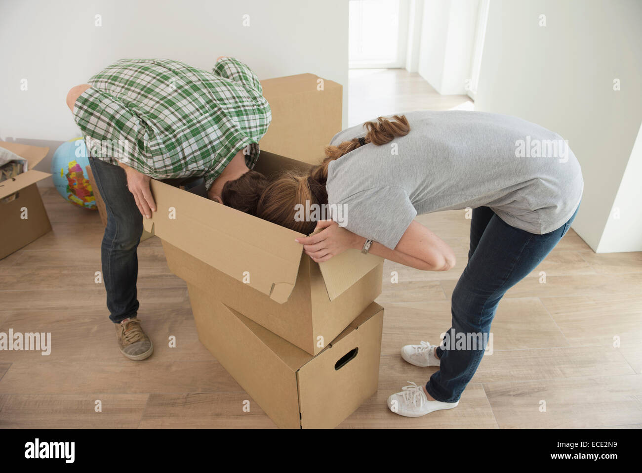 Couple looking searching inside packing box Stock Photo - Alamy