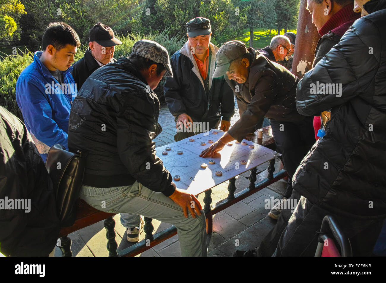 Two chinese man play Chinese chess, others watching Stock Photo - Alamy