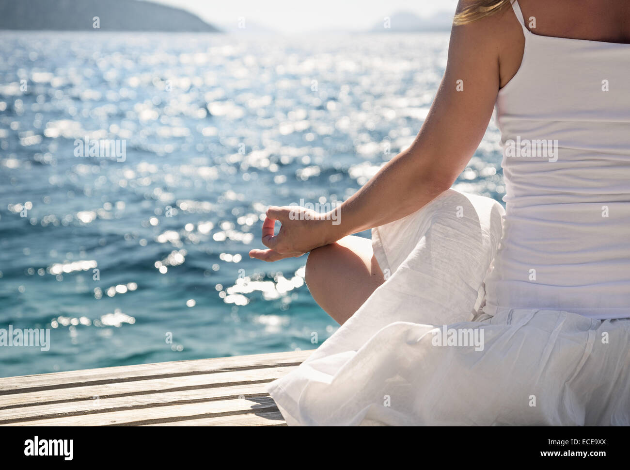 Woman meditating at the sea Stock Photo - Alamy