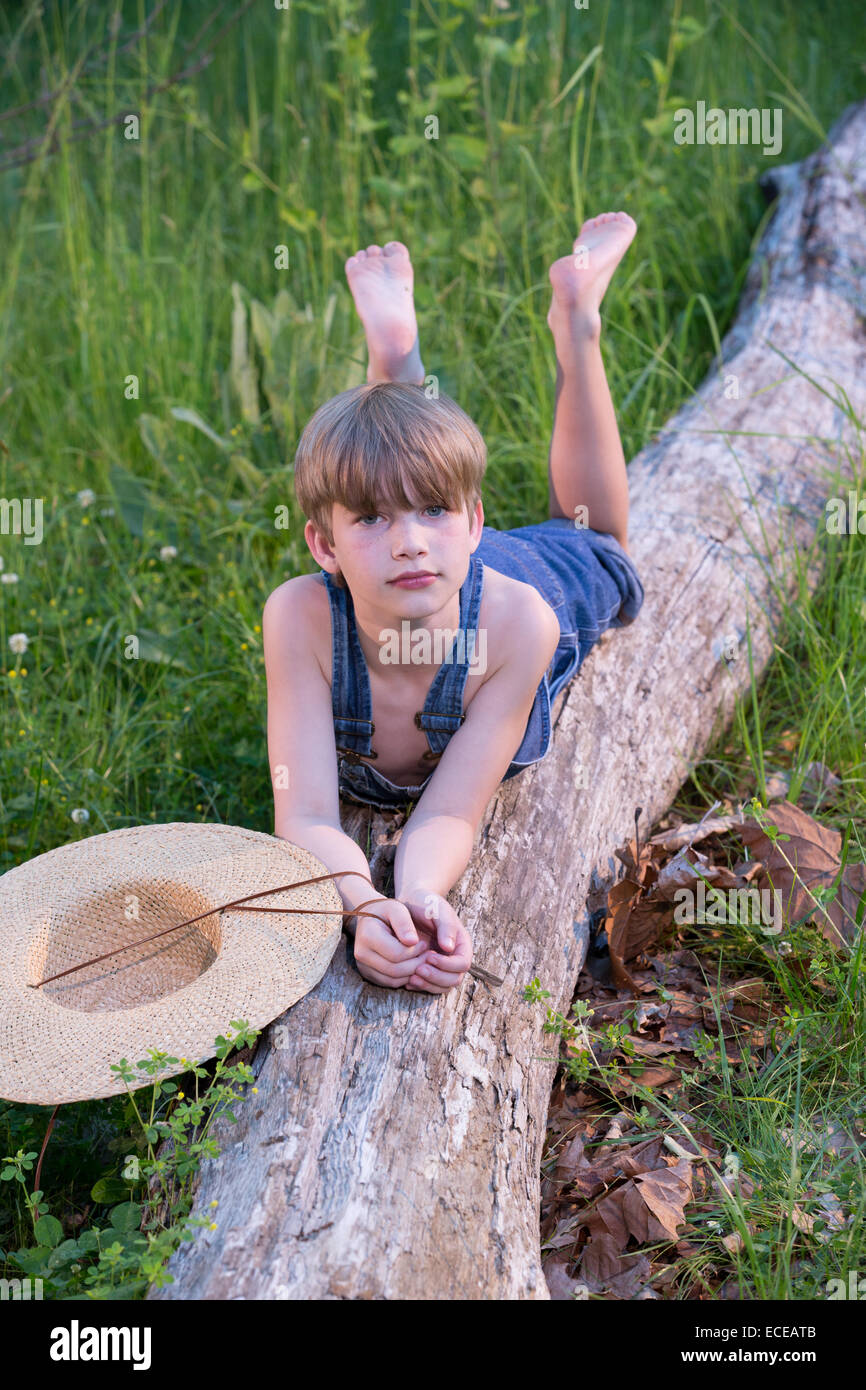 Boy lying on a tree trunk Stock Photo - Alamy