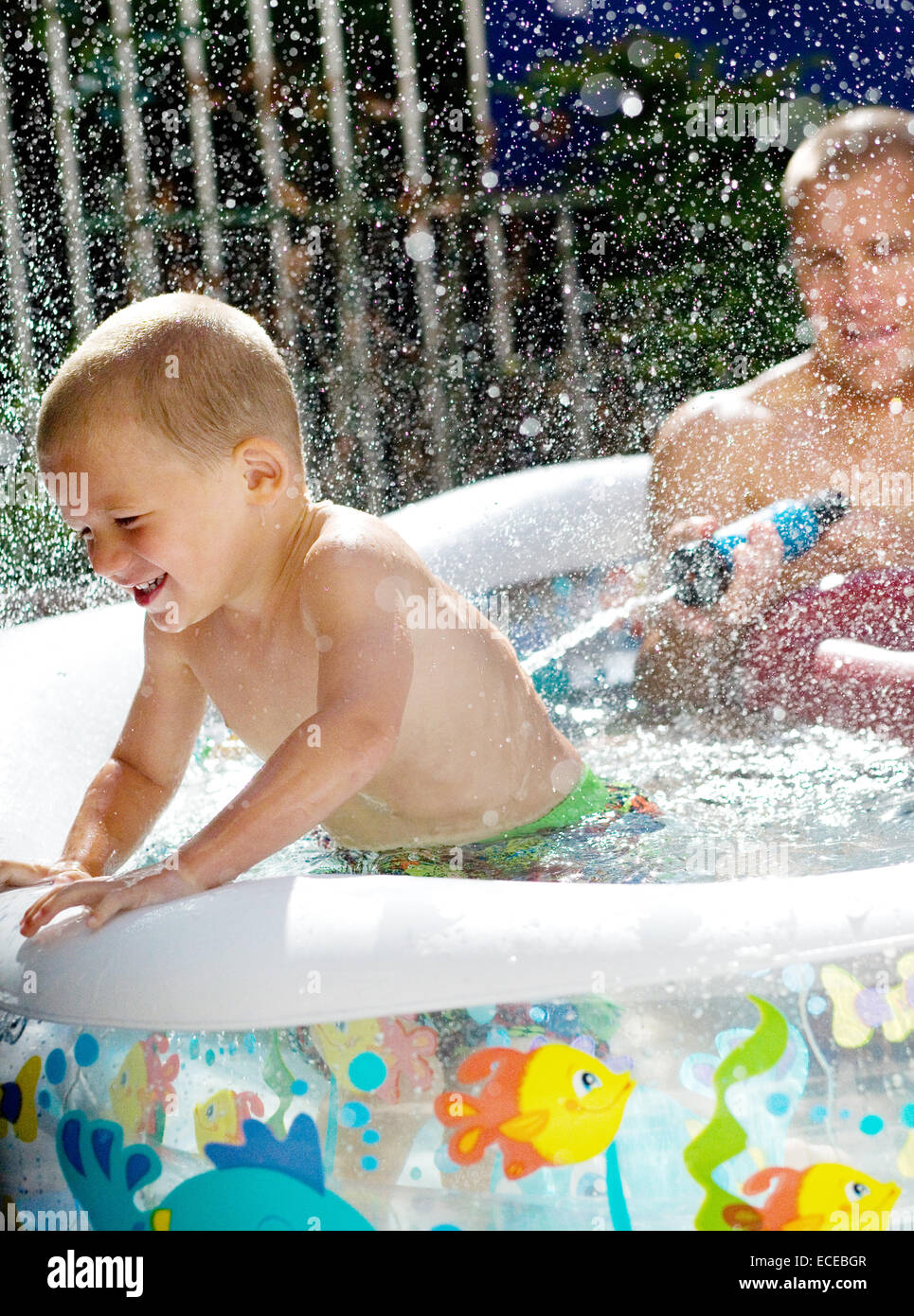 Father and son playing in inflatable swimming pool Stock Photo - Alamy