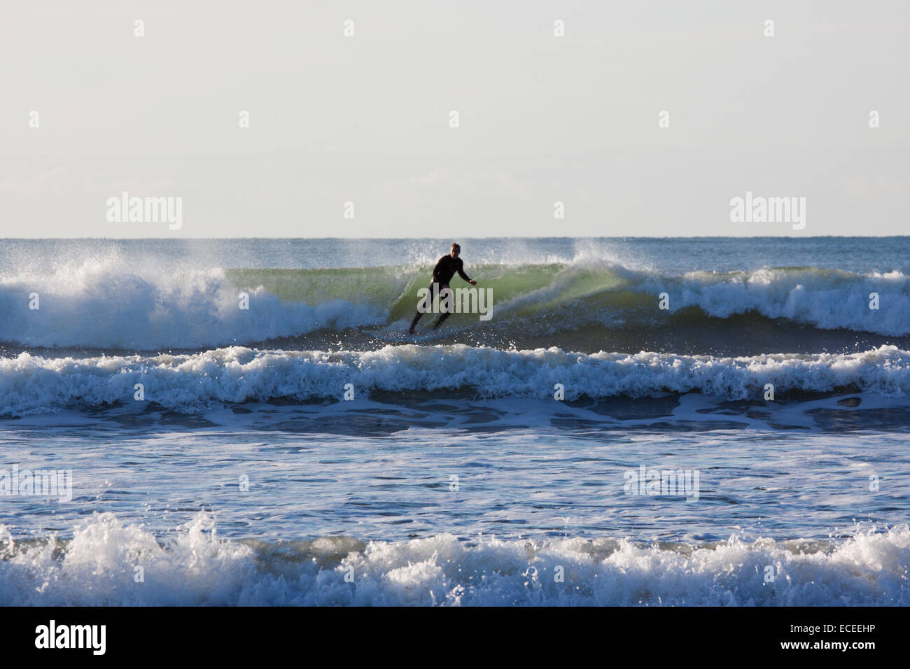 Surfer riding the waves at Saunton UK. The bay in North Devon is ...