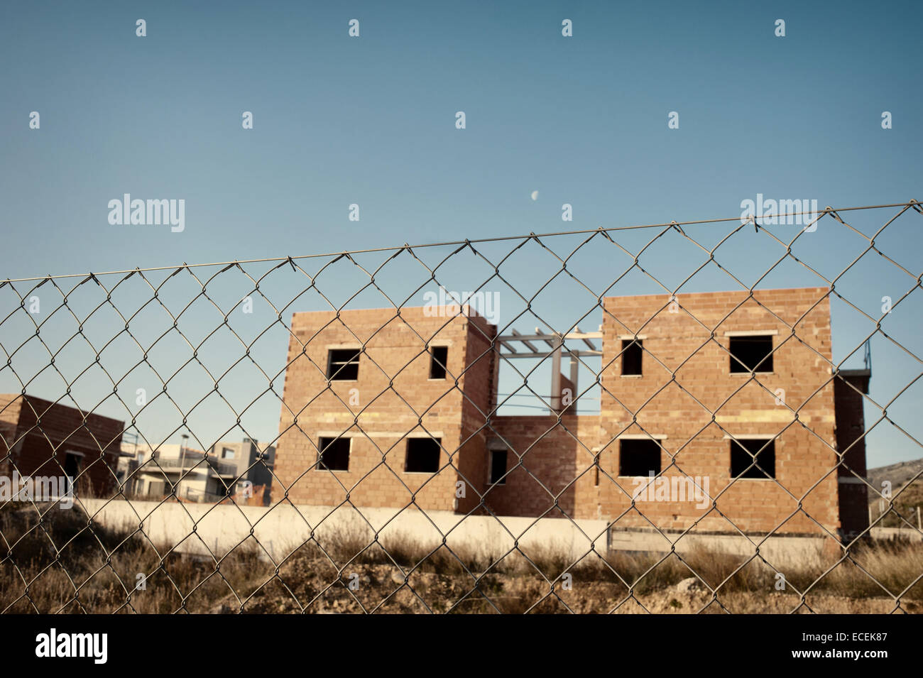 Fenced building site with abandoned unfinished houses Stock Photo - Alamy