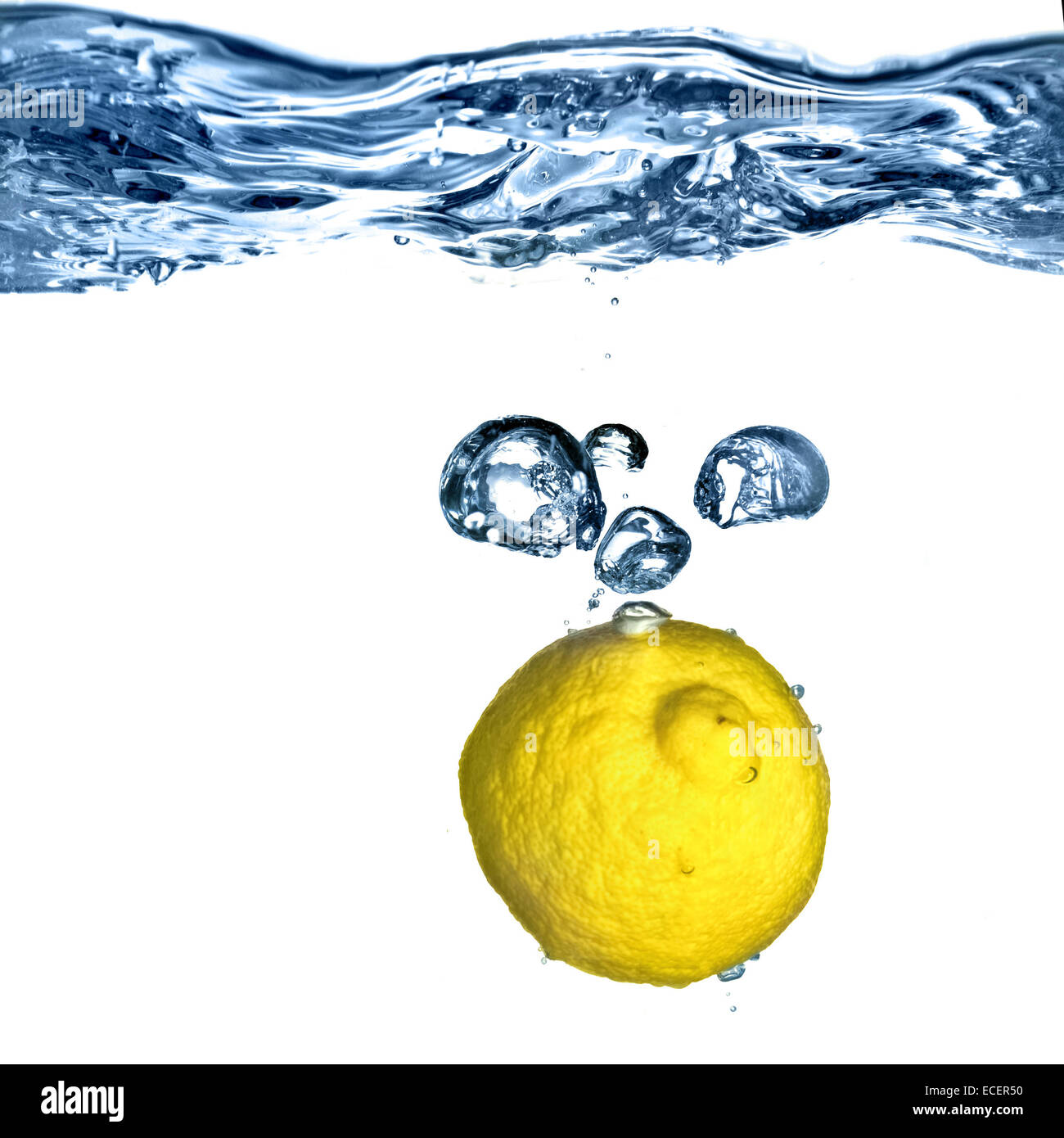 Fresh lemon dropped into water with bubbles isolated on white Stock ...