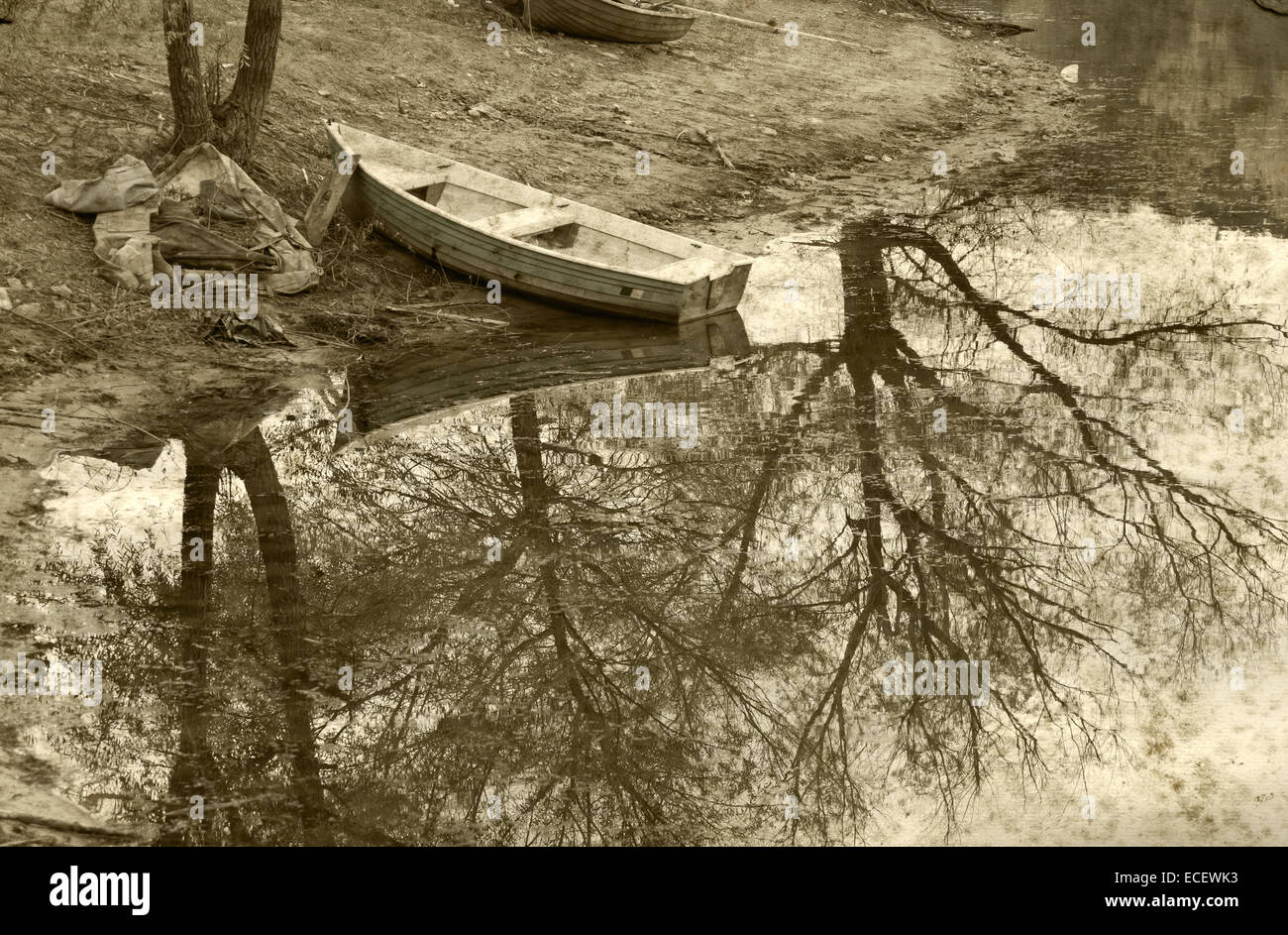 Old boat near the lake with the reflection of the trees on the water ...