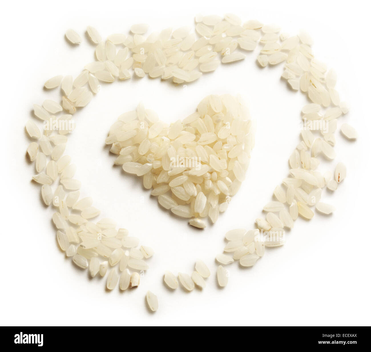 Heap of rice and heart form on white Stock Photo - Alamy