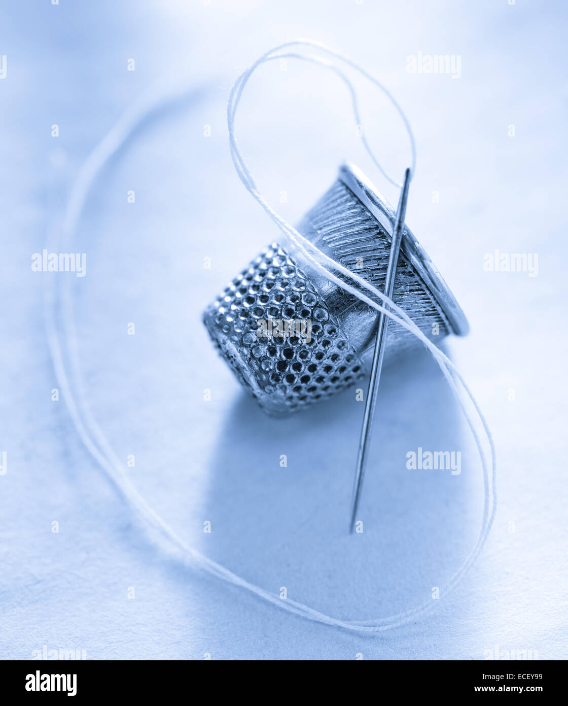 Metal sewing thimble and needle with thread Stock Photo - Alamy