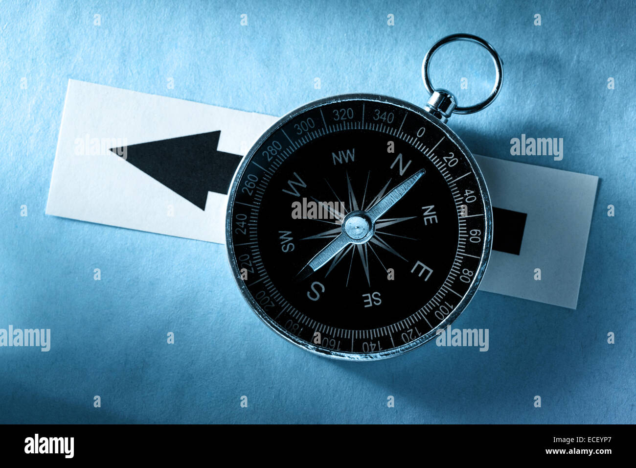 Compass and arrow in blue toning Stock Photo - Alamy
