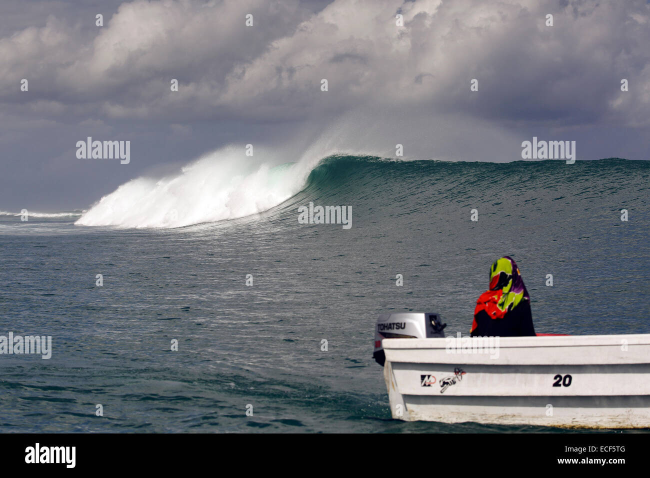 Person in boat watches a large surfing wave at Nembrala on Rote Island ...
