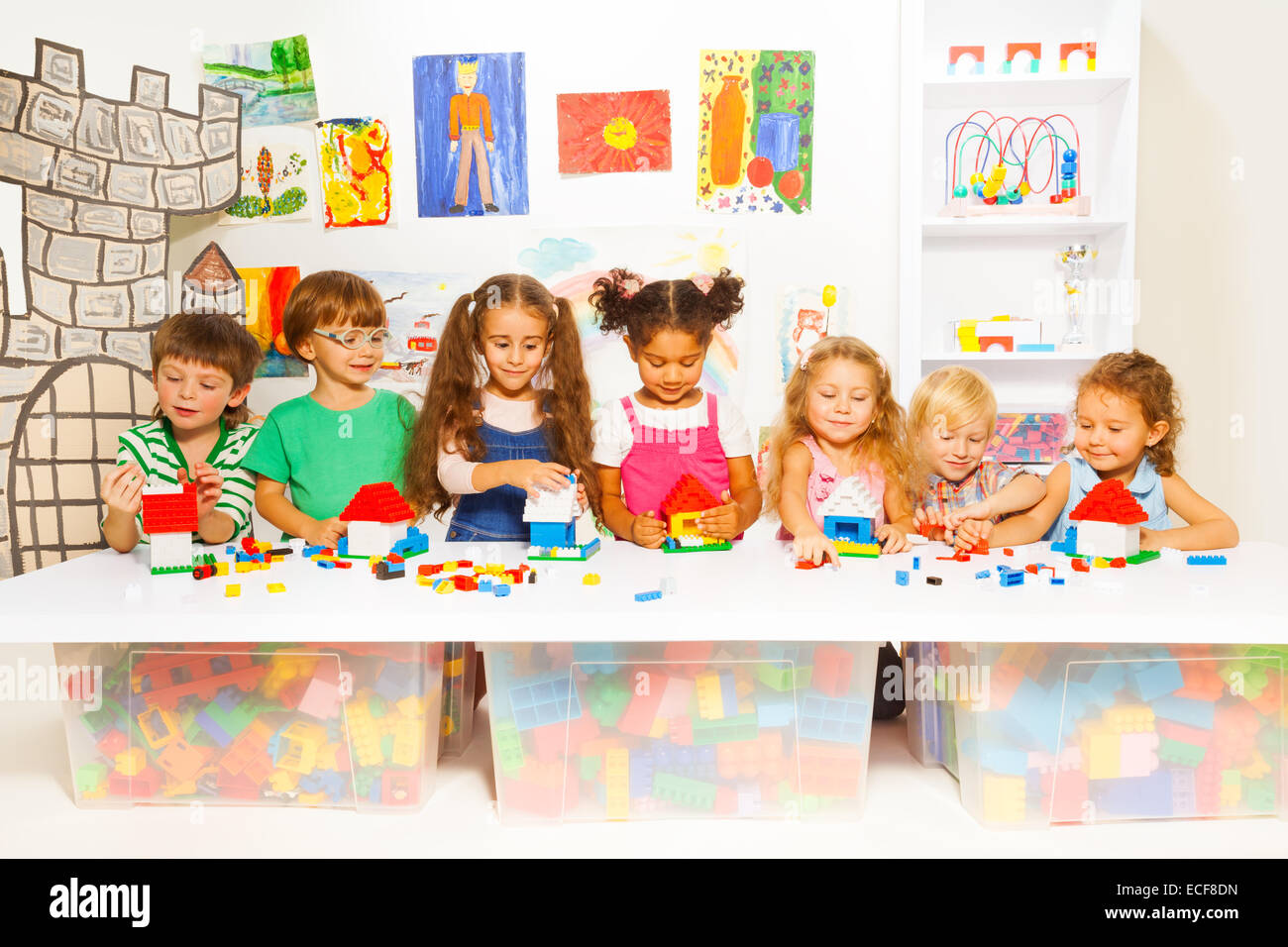 Group of happy kids playing with blocks in kindergarten class ...