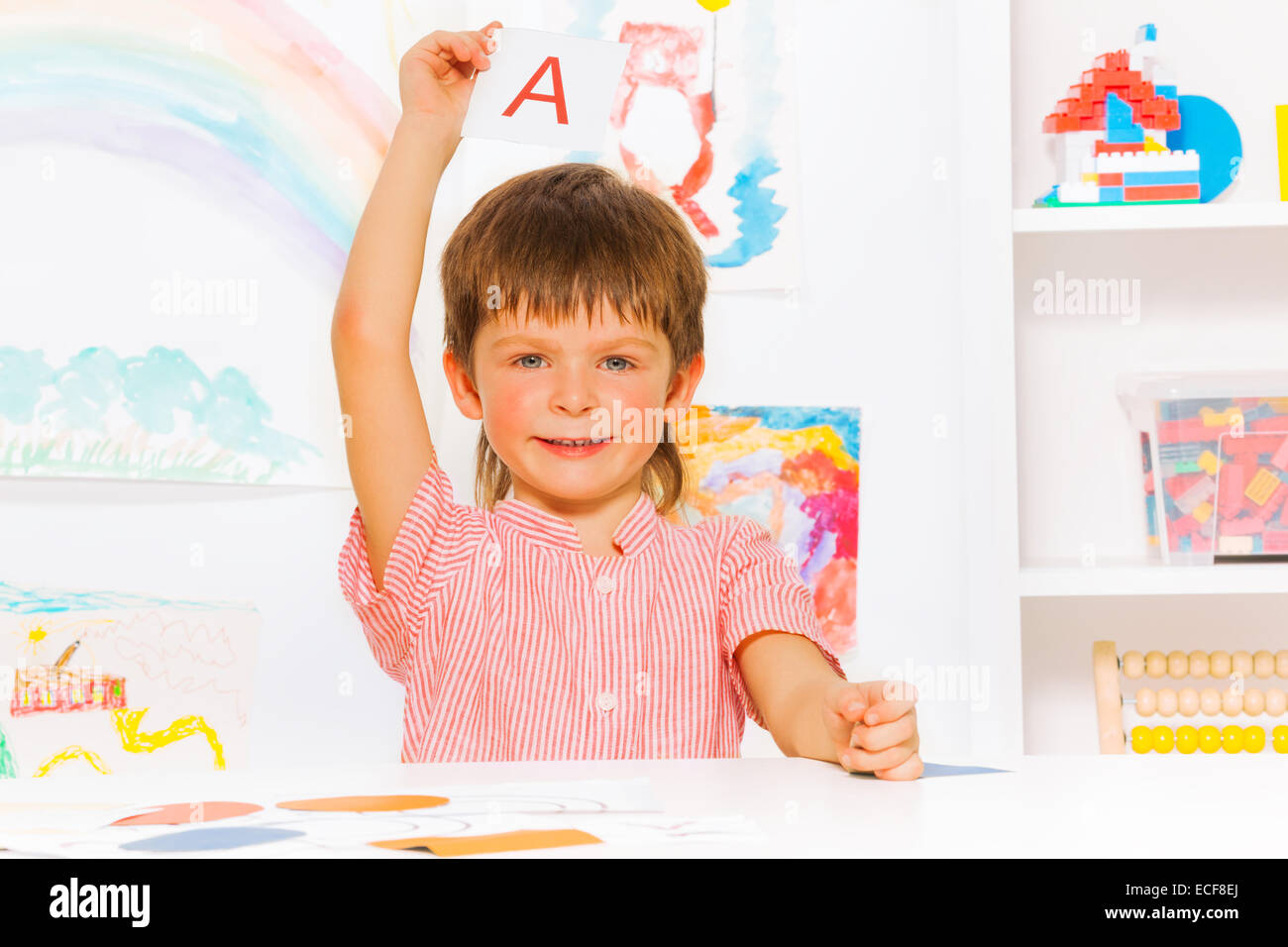 Smart little preschool boy showing flashcard with letter a in ...