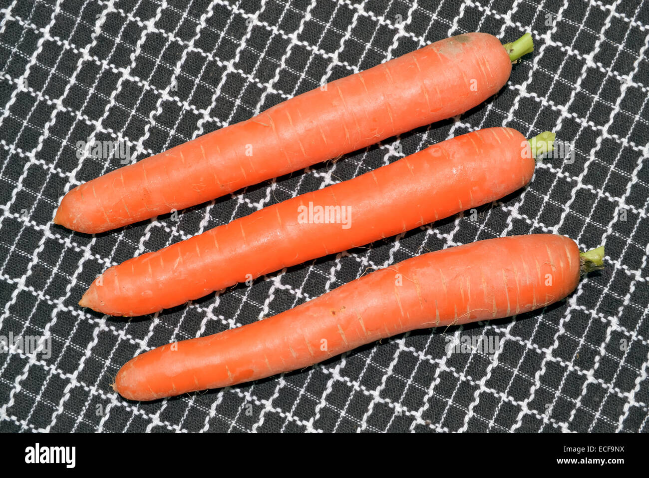 Three carrots placed on the kitchen table Stock Photo - Alamy
