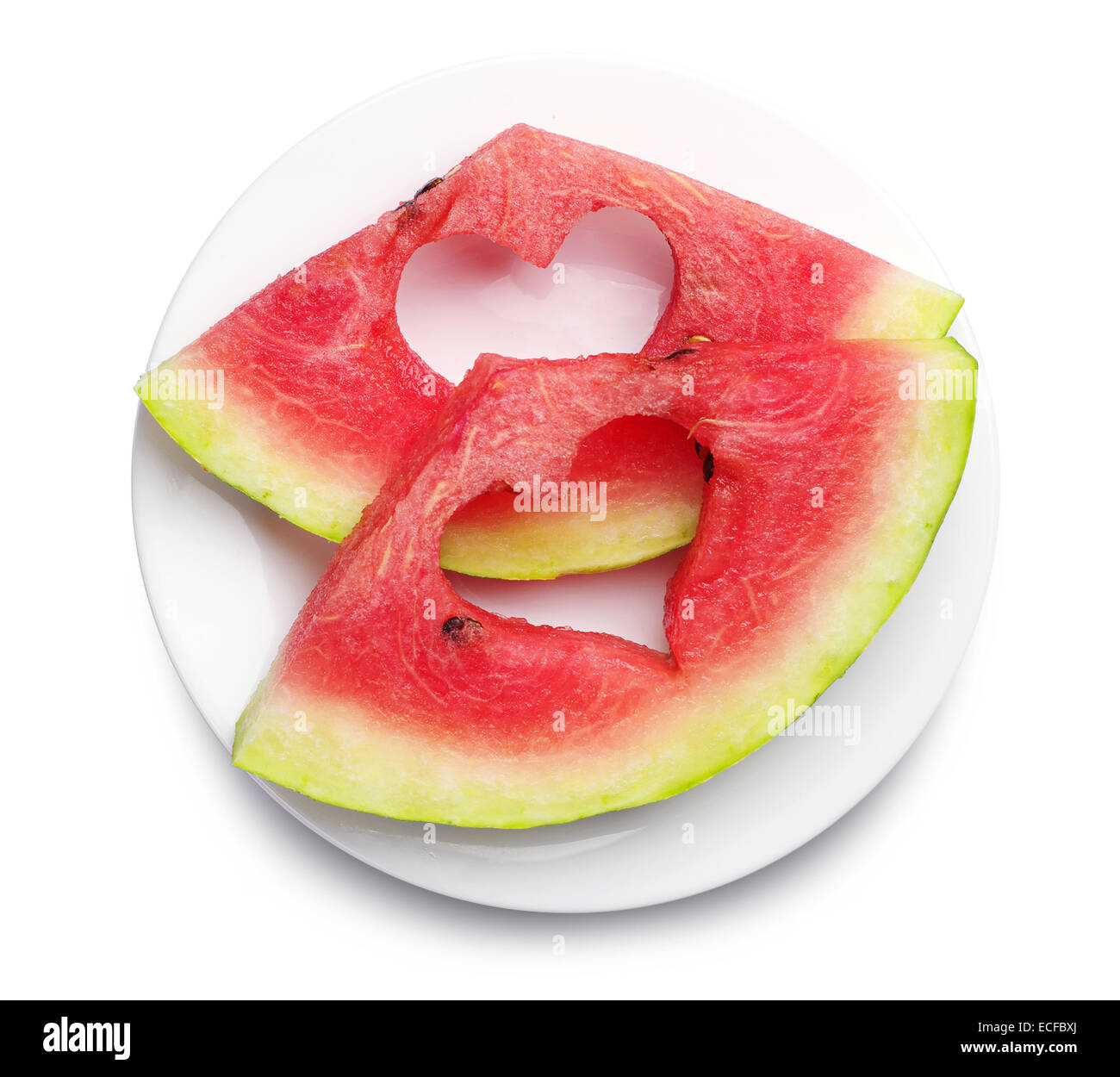 Slices of watermelon with cut out heart shape in plate on white ...