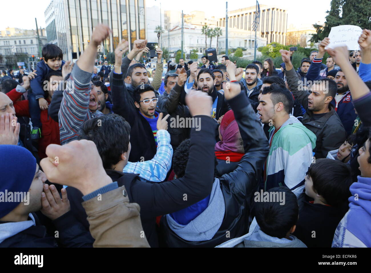 Syrian refugees shout slogans in a large crowd. Syrian refugees and ...