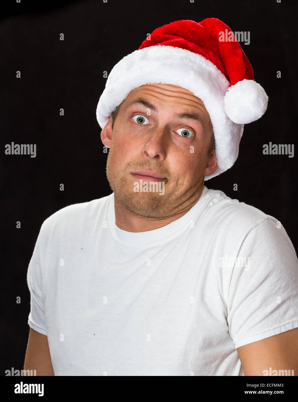 holiday portrait with a young caucasian male wearing a santa hat over a ...