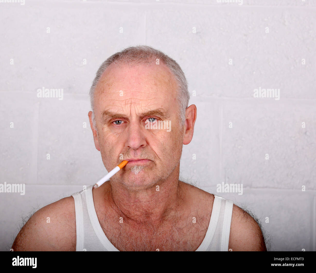 Mature guy smoking a cigarette unshaven wearing a vest, 13th December ...