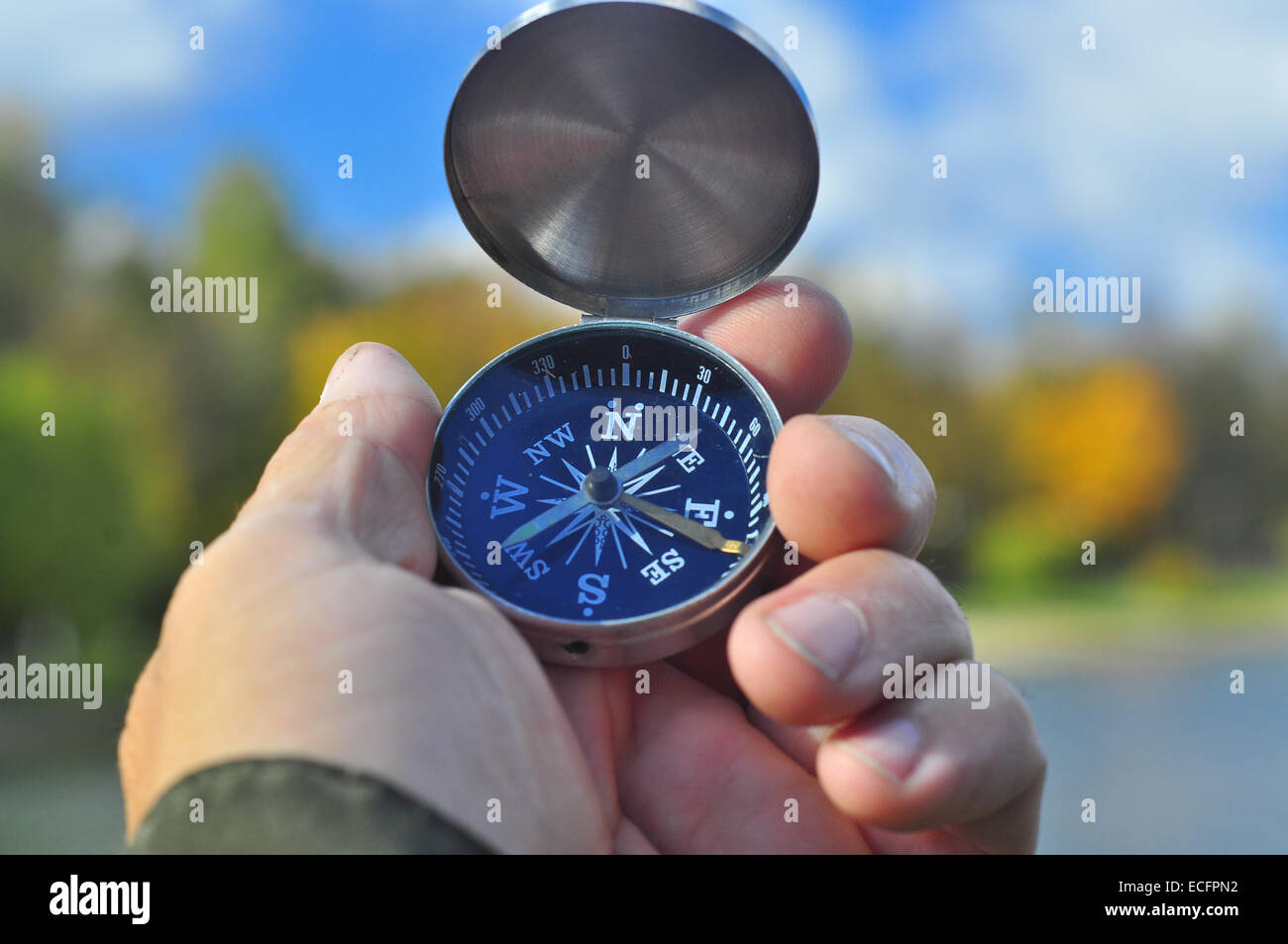 Compass and hand. The magnetic compass is in his hand on the autumn ...