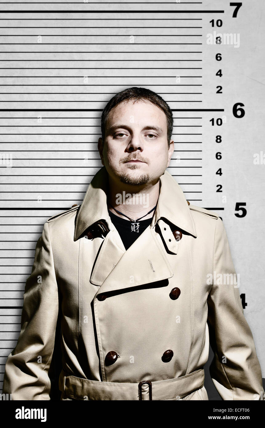 Killer standing on height ruler for photo in prison Stock Photo - Alamy